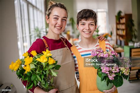 활기찬 꽃집 환경에서 미소를 지으며 아름다운 꽃꽂이를 보여주는 두 명의 젊은 여성 플로리스트 2명에 대한 스톡 사진 및 기타 이미지 Istock