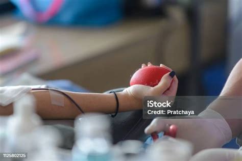 혈액을 수신 및 고무 공을 손에 들고 아시아 남자의 오른 팔을 닫습니다 건강 관리 그리고 자선입니다 수혈 혈액 기부입니다 세계 혈액 기증자의 날 헌혈에 대한 스톡 사진 및