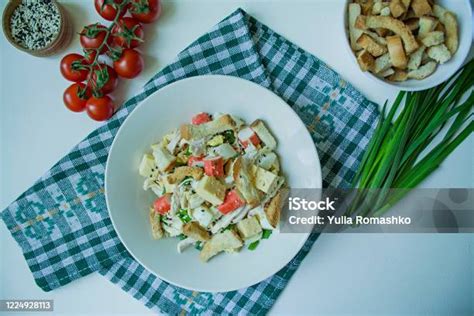 크래커 게 스틱 치킨 필레 신선한 허브 올리브 오일로 양념한 하드 치즈를 곁들인 샐러드가 화이트 플레이트에 담겨 나옵니다 위에서 볼 수 있습니다 흰색 배경입니다 곁들이는