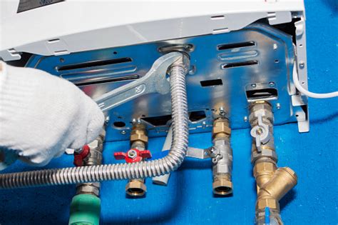 배관공은 조정 가능한 렌치를 사용하여 파이프 가스 보일러에 부착합니다 가스 보일러에 대한 스톡 사진 및 기타 이미지 가스