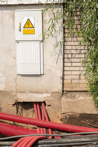 빨간색 골판지 파이프의 전기 케이블은 거리의 지하에 묻혀 있습니다 전기 케이블 인프라 설치의 허브 많은 Csuply 에너지 케이블이있는 건설 현장 묻힌에 대한 스톡 사진 및