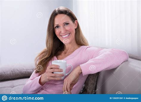 Happy Woman Sitting On Sofa Holding Coffee Cup Stock Image Image Of