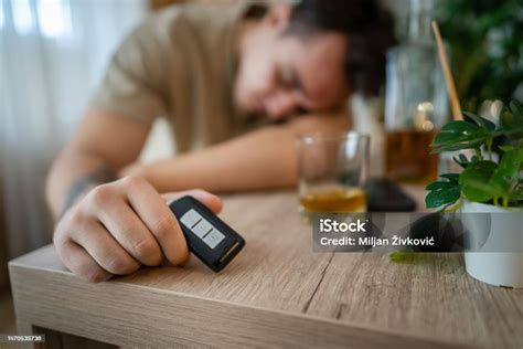 한 남자가 술 한 병을 들고 집에 앉아 위스키 술에 취해 알코올 중독 중독 남자 우울증 개념 술과 드라이브 복사 공간 자동차 열쇠 보유 숙취 의학적 상태에 대한 스톡 사진