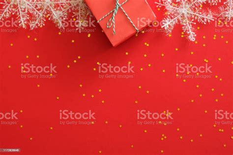 흰색 눈송이와 황금 반짝이 색종이와 빨간색 배경에 선물 크리스마스 선물 상자 최소한의 플랫 레이 스타일 컴포지션 상단 보기 복사 공간 Xmas 겨울 휴가 새해 개념입니다 0