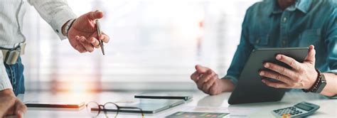 사업가 고문 두 명의 비즈니스 사람들이 말하고 사무실에서 태블릿에 대한 투자 및 마케팅을 분석 할 계획 2명에 대한 스톡 사진