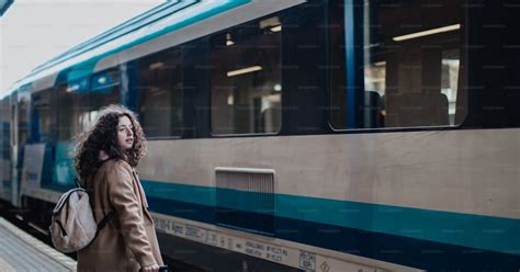 기차역 플랫폼에서 기차를 기다리는 짐을 가진 행복한 젊은 여행자 여자 사진 Unsplash의 여행 가방 이미지