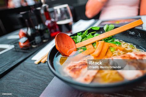 구운 닭고기와 신선한 야채를 곁들인 맛있는 일본 전통 라멘 한 그릇으로 어두운 테이블 위에 진한 육수와 나무 숟가락이 놓여 있습니다 Comfort Food에 대한 스톡 사진