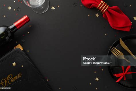 블랙 프라이데이의 우아한 식사 경험 검은색 배경에 접시 선물 상자 식기류 냅킨 메뉴북 와인병 유리잔 색종이 조각이 있는 아름답게 세팅된 테이블의 상단 보기 승진을 위한