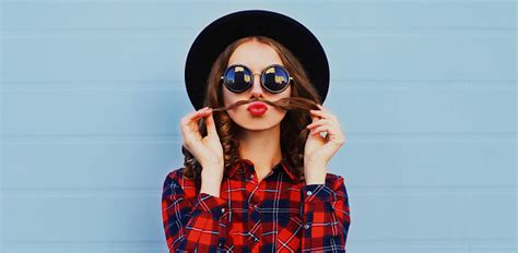 파란 배경 위에 검은 둥근 모자를 쓰고 빨간 입술을 불고 콧수염을 보여주는 재미있는 여자의 초상화 클로즈업 25 29세에 대한 스톡 사진 및 기타 이미지 Istock