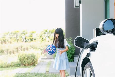 흐릿한 어린 소녀 배경을 가진 초점 Ev 충전기의 진보적인 기술 개념 프리미엄 사진
