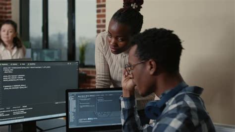 App Developer Removing Glasses While Explaining Algorithm To Colleague
