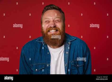 Adult Bearded Tattooed Handsome Tense Redhead Man With Closed Eyes And Clenched Teeth Standing