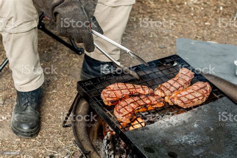 캠프 파이어에서 주철 그릴 접시에 굽는 쇠고기 스테이크 캠프 파이어 요리 야외 바베큐 고기에 대한 스톡 사진 및 기타 이미지