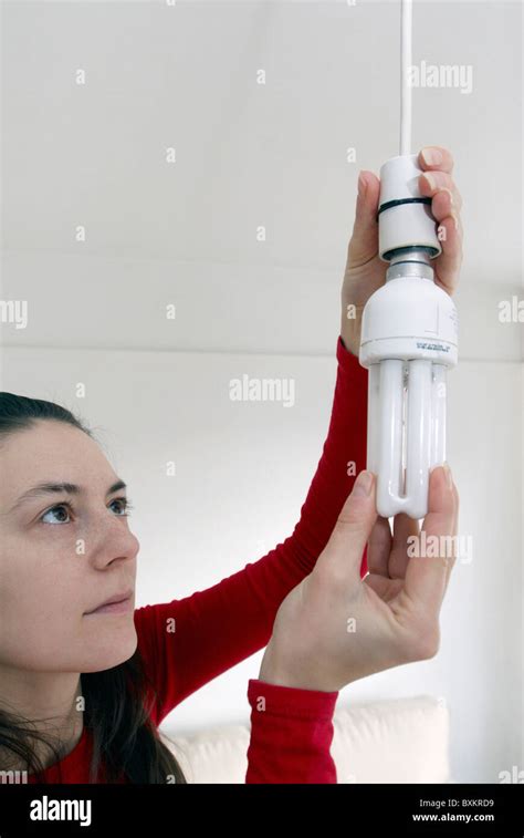 Woman Putting In Energy Saving Light Bulb Stock Photo Alamy