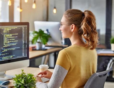 Premium Photo Rear View Of Woman Programmer Sitting At Desk Working With Computer In Start Up