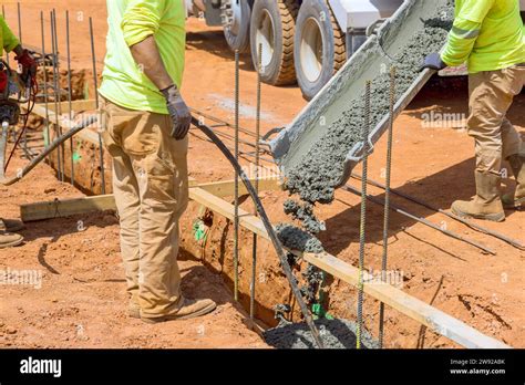 Using Concrete Vibrator Construction Worker Compacts Concrete Into Trenches For Foundation Of
