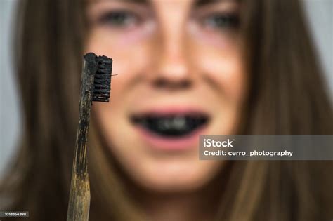 활성 숯 검은 치아 붙여넣기로 그녀의 이빨을 칫 솔 질 하는 젊은 여자 및 치아에 대 한 흰색 바탕에 검은색 칫 솔 미 백 건강관리와 의술에 대한 스톡 사진 및 기타 이미지
