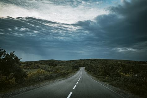 낮 동안 파란색과 흰색 맑은 흐린 하늘 아래 푸른 잔디밭 사이의 회색 아스팔트 도로 사진 Unsplash의 무료 그루지야 이미지