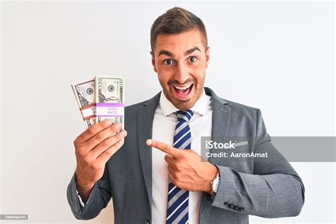 젊은 잘 생긴 사업가 보유 무리의 달러 지폐 위에 고립 된 배경 매우 행복 가리키는 손과 손가락 가리키기에 대한 스톡 사진 및 기타 이미지 Istock