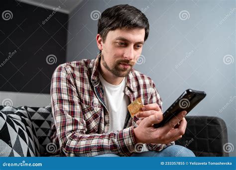 Safe Sex Concept Man Talking On Video Call With Girl Holds Gold Colored Condom In His Hand