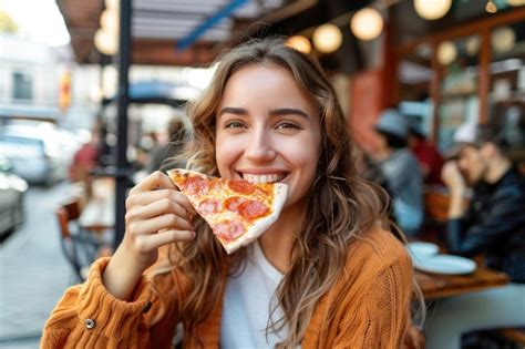 Premium Photo Happy Woman Eating Slice Of Pizza At Sidewalk Cafe