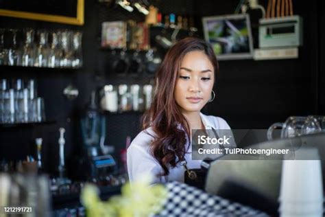 아시아 여성 바리스타 미소 와 커피 숍 카운터에서 커피 머신을 사용하여 일하는 여성 중소 기업 소유자 음식과 음료 카페 개념