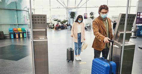 의료 마스크를 쓴 남성 승객이 안전한 거리에 줄을 서 있는 동안 수하물 무게를 확인하는 여성 사진 Unsplash의 수하물 이미지