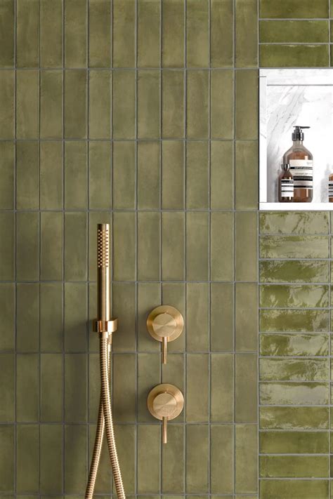 Красивое сочетание зеленой плитки с золотой сантехникой