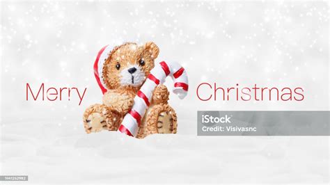메리 크리스마스 텍스트와 빨간 모자와 사탕 줄무늬 지팡이 스틱이 눈 덮인 배경에 격리된 테디 베어 인사말 기프트 카드 또는
