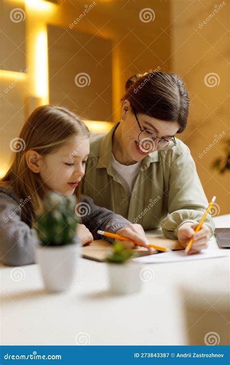 Individual Lesson With First Grader Teacher And Pupil In Mortarboard