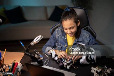 바쁜 소녀는 사무실 램프에 의해 조명 어두운 방에 그녀의 책상에 앉아 십대는 처음부터 로봇을 구축 장난감을 전원 전자 시스템을 만들기 위해 와이어를 연결 Stem 주제에