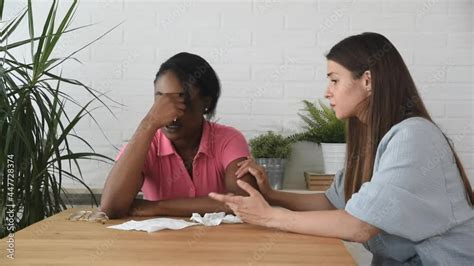 Two Young Women Of Mixed Race Lesbian Couple Sitting In Their Home And