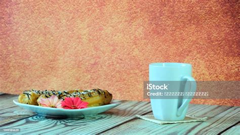 흰색 세라믹 머그잔에 차와 3개의 에클레어가 있는 접시 그리고 나무 탁자 위에 빨간 꽃이 서 있습니다 갈색에 대한 스톡 사진 및 기타 이미지 Istock