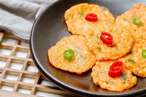 Premium Photo 검은색 접시에 빨갛고 녹색의 고추와 함께 담겨진 한국 전통 음식 김치전 요리