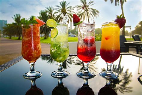 고명 과일 장식 과일 조각 과일 주스 다채로운 음료 도시 야외 도시 풍경 두바이 딸기 라임 맑은 날 맛있는 음료 망고 민트 반사 테이블 밝은 색