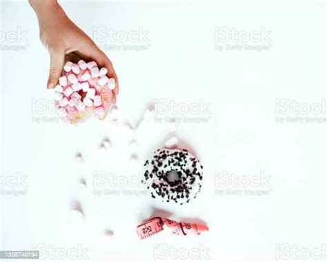 여성의 손은 흰색 배경 위에 테이프를 측정 도넛을 들고 상단 보기 플랫 레이 건강에 좋지 않은 음식에 대한 스톡 사진 및 기타 이미지 건강에 좋지 않은 음식 공란