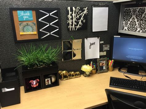 An Office Cubicle With Desk Computer And Plants On The Wall Above It
