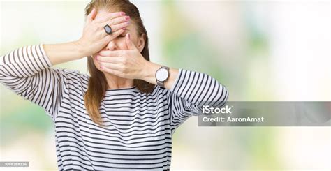 중간 나이 성숙한 아름 다운 여 인 격리 된 배경 덮 음 눈과 손으로 입을 줄무늬 겨울 스웨터를 입고 놀 랐 고 충격 감정