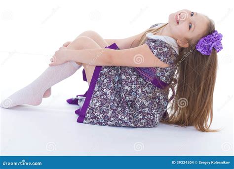 Очаровательная маленькая девочка сидя на поле Стоковое Фото изображение насчитывающей