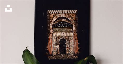 검은 색과 갈색 벽 장식 외에 녹색 잎이 달린 식물 사진 Unsplash의 무료 이슬람 예술 이미지