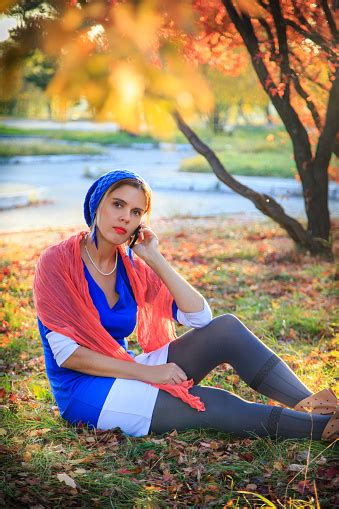 가 공원에 아름 다운 행복 한 젊은 여자 즐거운 여자는가 밝은 노란색 나무 야외에서 스마트폰 이야기입니다 가로수에 대한 스톡 사진 및 기타 이미지 Istock