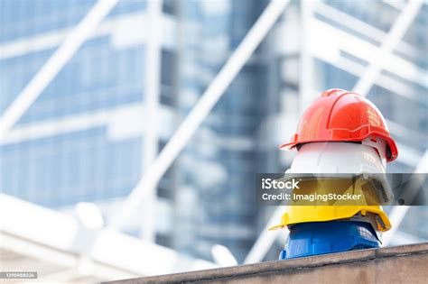 콘크리트 바닥 도시 야외에서 엔지니어링 또는 프로젝트 작업자장소로 일하는 작업자의 안전 프로젝트를 위해 파란색 노란색 흰색 및 빨간색 하드 안전 헬멧 모자를 닫습니다 0명에