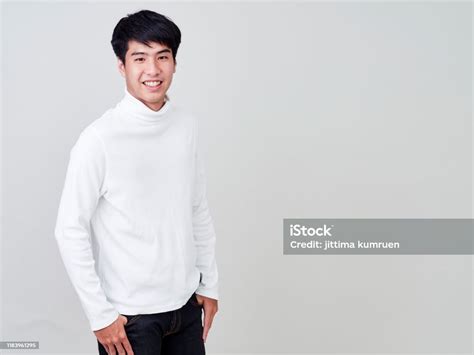 흰색 배경에 흰색 스웨터를 입고 젊은 아시아 남자의 스튜디오 초상화입니다 25 29세에 대한 스톡 사진 및 기타 이미지 25 29세 가리키기 겨울 Istock
