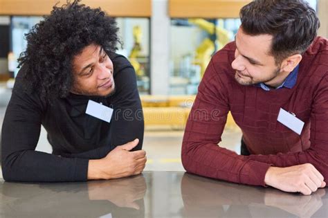 Engineers Examining Robotic Gripper Arm During Industrial Automation Training Session Stock