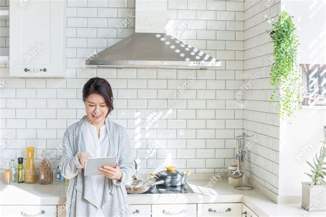 중년 성인 중년여자 성인여자 요리하기 음식준비 인공지능 스피커 홈오토메이션 기술 디지털태블릿 개인용컴퓨터 미소 이미지 Jv11341243