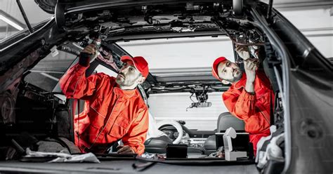 빨간 유니폼을 입은 두 명의 자동차 서비스 직원이 실내에서 일부 개선을 하는 새 차 인테리어를 분해합니다 사진 Unsplash의 설치 이미지