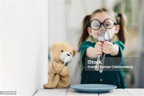 작은 귀여운 아이는 손 포크와 숟가락에 잡고 칼붙이를 사용하는 법을 배워 가정 생활에 대한 스톡 사진 및 기타 이미지 가정 생활 가정 주방 가정의 방 Istock
