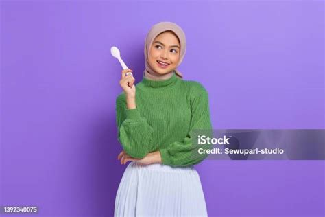 배고픈 아름다운 아시아 여자 에 녹색 스웨터 들고 숟가락 생각 의 맛 있는 음식 고립 된 위에 보라색 배경 먹기에 대한 스톡 사진 및 기타 이미지 Istock