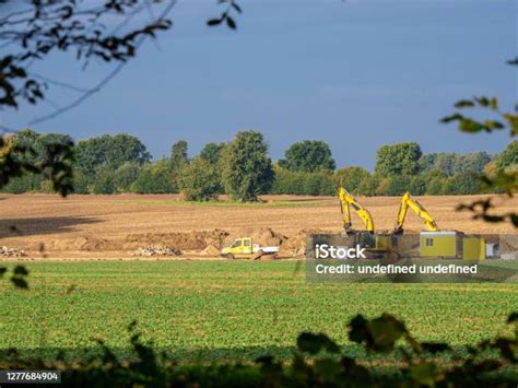 굴삭기 와 다른 기계는 큰 콘크리트 파이프를 묻기 위해 필드에 서 강철에 대한 스톡 사진 및 기타 이미지 강철 개발 건축 Istock