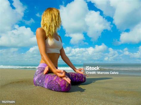 젊고 행복 하 고 매력적인 금발 소녀 요가 및 집중력 휴식과 웰빙과 건강 한 라이프 스타일에 로터스 위치에 앉아 명상 연습에 아름 다운 해변에서 야외 운동 가냘픈에 대한